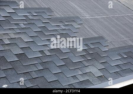Installing bitumen roof shingles Stock Photo - Alamy