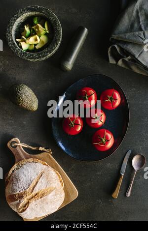 From above of vegetarian guacamole with tomatoes and lime garnished ...