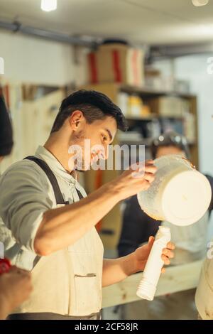Happy carpenter holding a bottle with glue. Process of creating ...