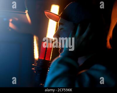 Male rapper with headphones standing in recording studio Stock Photo ...
