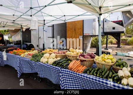 Farmer selling many different vegetables and fruits in a booth at Las ...