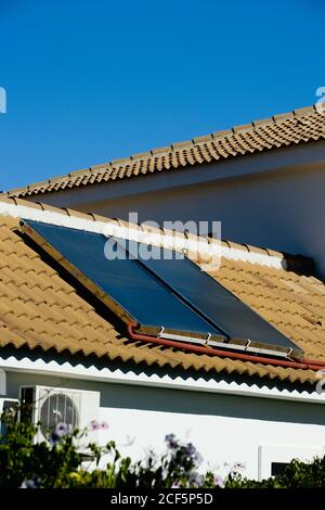 Solar panels are installed on a blue structure in a green landscape ...