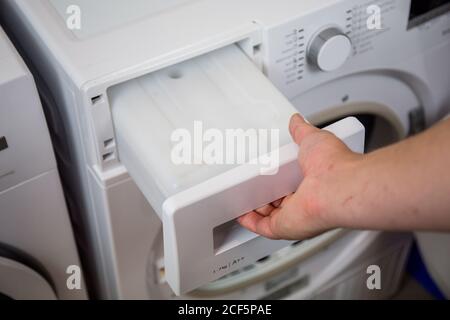 clothes dryer water tank, man maintains the machine regularly, empties ...