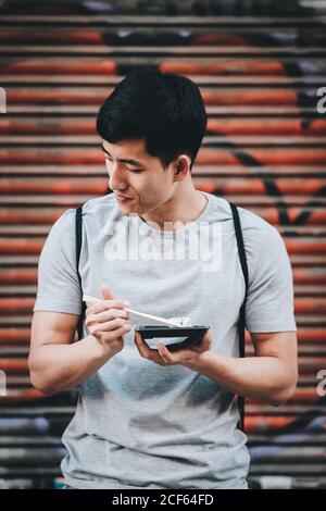 Handsome man eating street food corn at fast food festival Stock Photo ...