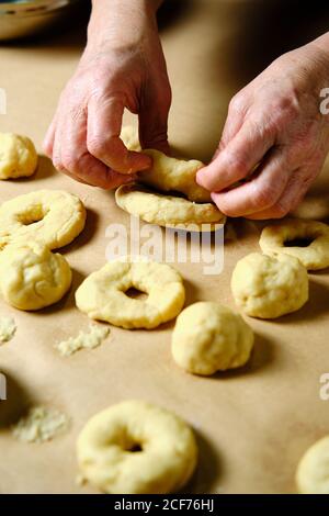 From above rings from soft dough while preparing doughnuts over table ...