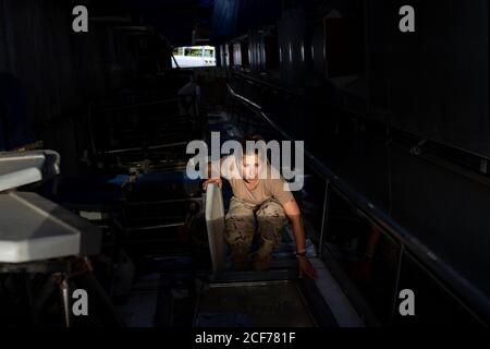 Side view of strong female soldier pointing up while looking at sky ...