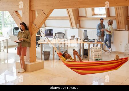 Modern business colleagues using mobile app and discussing infor Stock ...