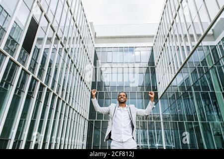 Successful businessman rejoicing, raising hands up and celebrating ...