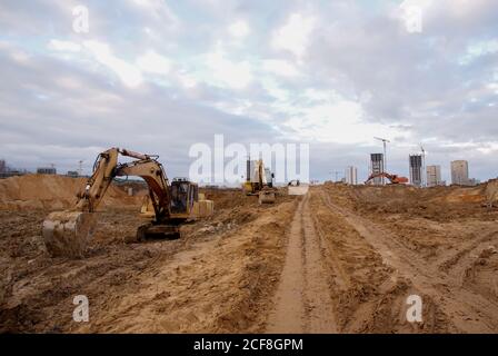 Group of the excavators for dig ground trenching at a construction site ...