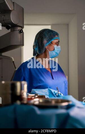 Blurred doctor in medical mask holding pyrometer isolated on grey,stock ...