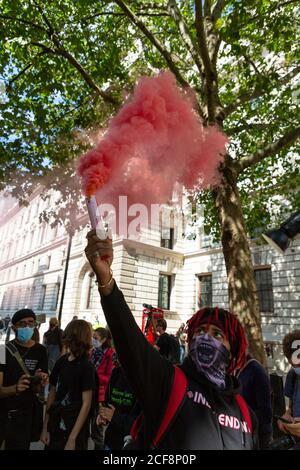 A protester holds a red flare during the demonstration. During a far ...