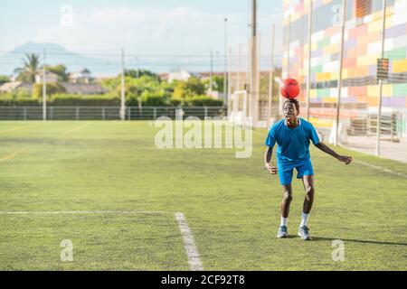 Skinny black teenager jugging football ball on head Stock Photo - Alamy
