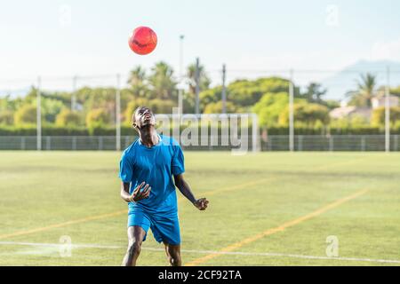 Skinny black teenager jugging football ball on head Stock Photo - Alamy
