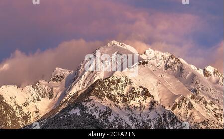 A scenic view of a mountain partially covered with snow under the ...