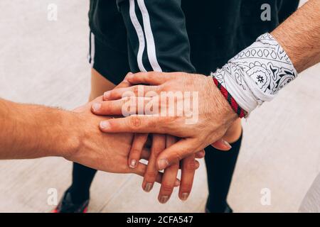 Young people putting hands together in office Stock Photo - Alamy