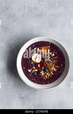 A top view of an Acai bowl with berries, peanut butter and granola ...
