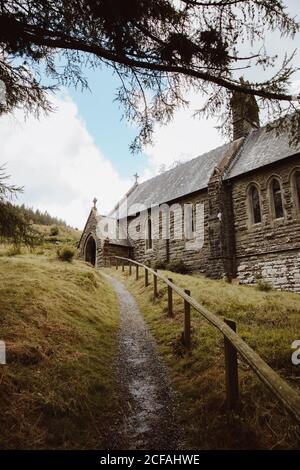 From below road with wooden railing leading up to green hill with ...