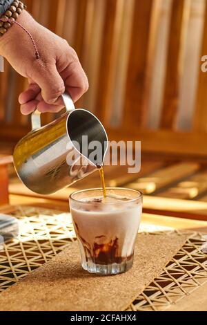 Glass of tasty iced coffee and pot on table, closeup Stock Photo - Alamy