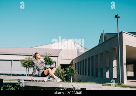 trendy businessWoman working outside sitting on round decorative panel ...