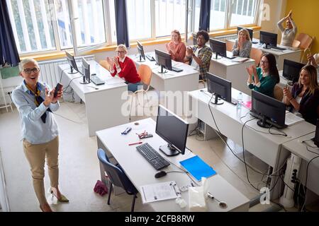 Students clapping hands in classroom Stock Photo - Alamy