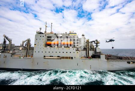 USNS Matthew Perry steams alongside the aircraft carrier USS Nimitz in ...