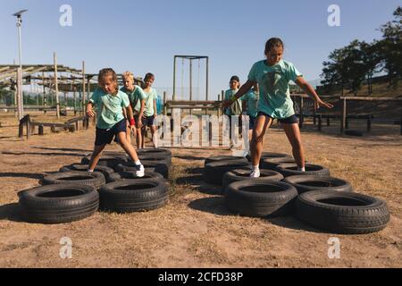 Group of kids walking through tires during obstacle course at a boot ...