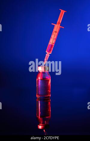 Syringe and drug bottle on red background Stock Photo - Alamy