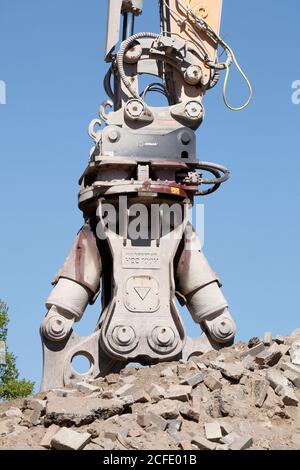 Demolition excavator on the wreckage of a demolished air-raid shelter ...