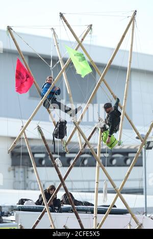 Two protesters use bamboo lock-ons to block the road outside the ...