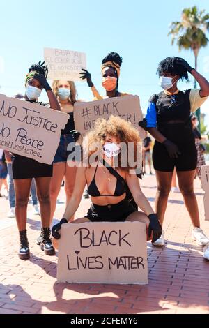 Crowd kneeling together at Black Lives Matter protest in front of white ...