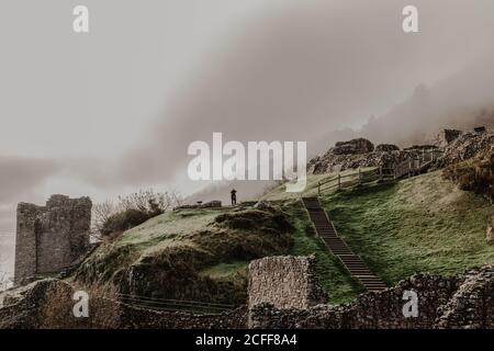Destroyed old stone castle with fog with walls and stairs with tower on ...