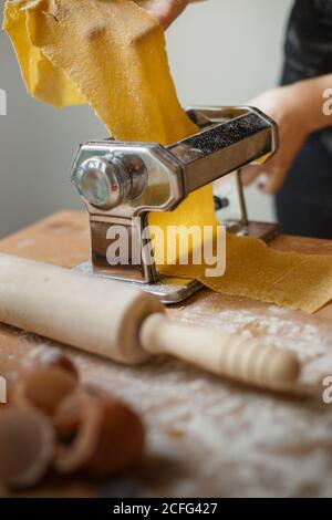 Pasta machine with dough on wooden table Stock Photo - Alamy