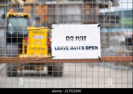 Do not leave gates open sign at construction site Stock Photo - Alamy