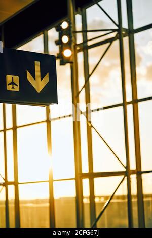 Black sign with yellow arrow pointing direction and airplane location ...
