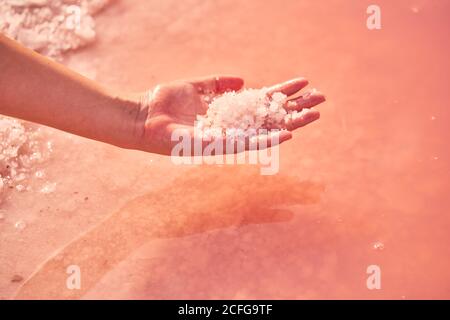 Female holding healing salt pile in pink water Stock Photo - Alamy