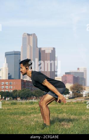 Male sportsman stretching hand while jumping on walkway Stock Photo - Alamy