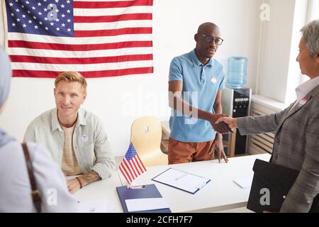 An election worker hands a voter their ballot at Alexandria City Hall ...