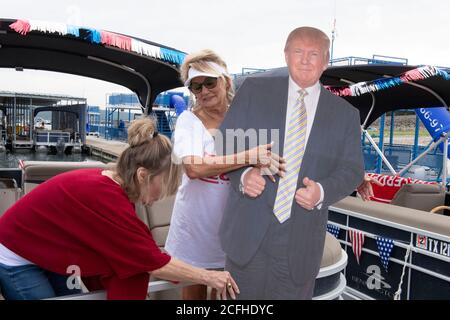 Lake Travis, Texas USA: Two teen girls practice turning over a capsized ...