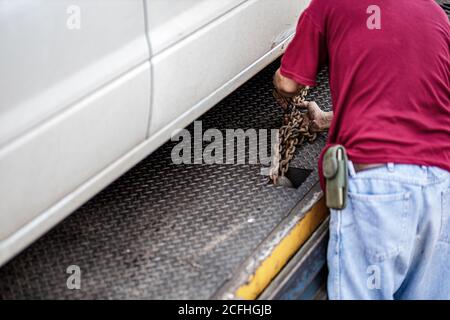 A man check chain bind car wheel on car tow in the park. Damage and ...