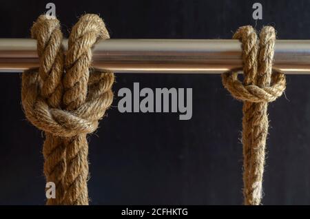 Guard rail with tied ropes on it. Close-up of a metal pipe with a ...