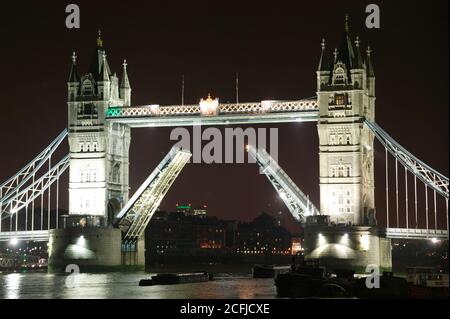 Tower Bridge at night with its drawbridge open on the River Thames in ...