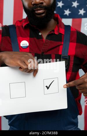 Young african american man voting indoors in front of an irish flag at ...