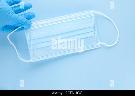 Gloved Hand Holding Blue Disposable Surgical Face Mask on Gray ...