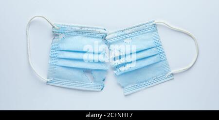Used, broken, and torn medical face mask. Showing dangerous lack of ppe ...