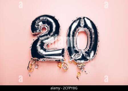 Silver number 20 celebration foil balloon against blurred light ...