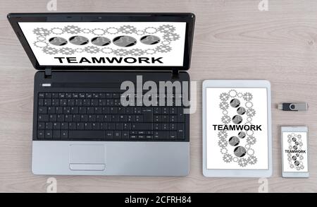 Teamwork concept shown on different information technology devices ...