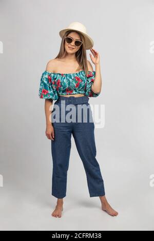 White summer hat, sun glasses and flip flops over the sand on a ...