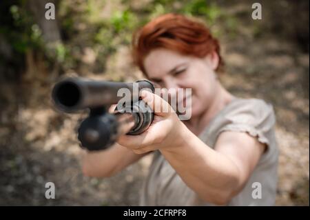 Woman shooting with pump gun. Direct macro detail close-up shotgun ...