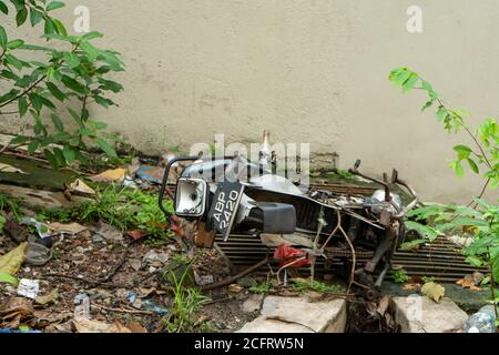 A rusty half-destroyed bike is lying on the lawn. Landfill of old ...