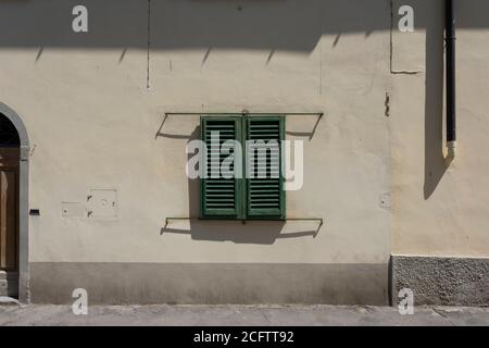Italian style wooden window with closed shutter blinds on brick wall ...
